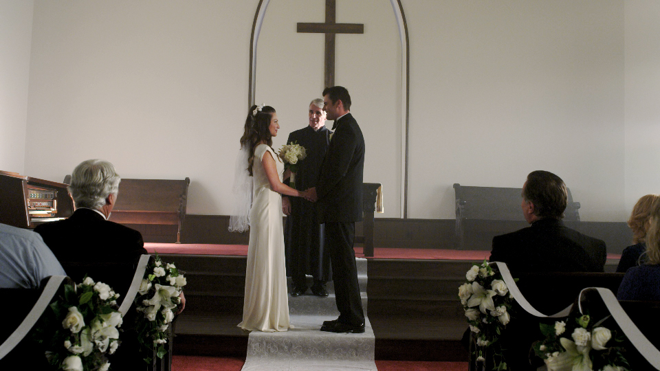 Preacher talking to a bride and groom in a chapel